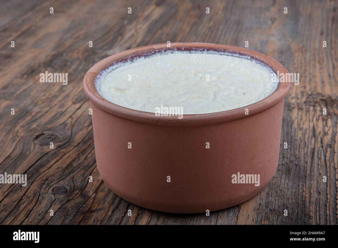 Natural,yogurt in casserole bowl on wooden table with spoon.Close up ...