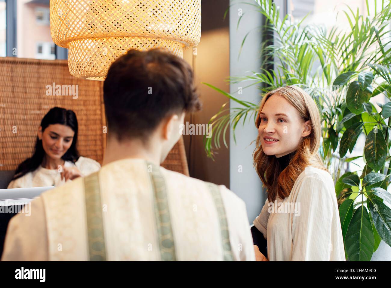 Young coworkers talking together Stock Photo - Alamy