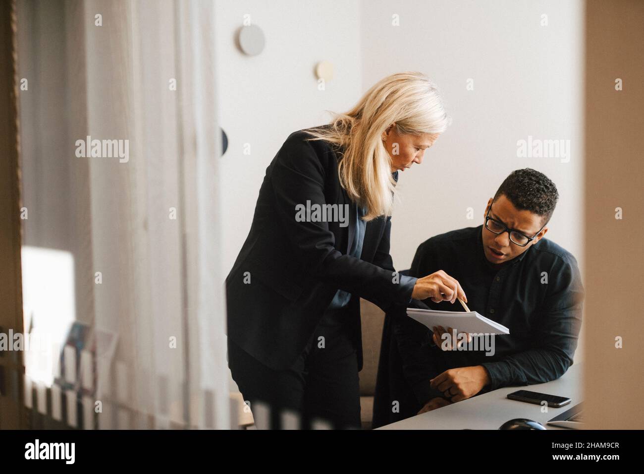 Coworkers talking in office Stock Photo - Alamy