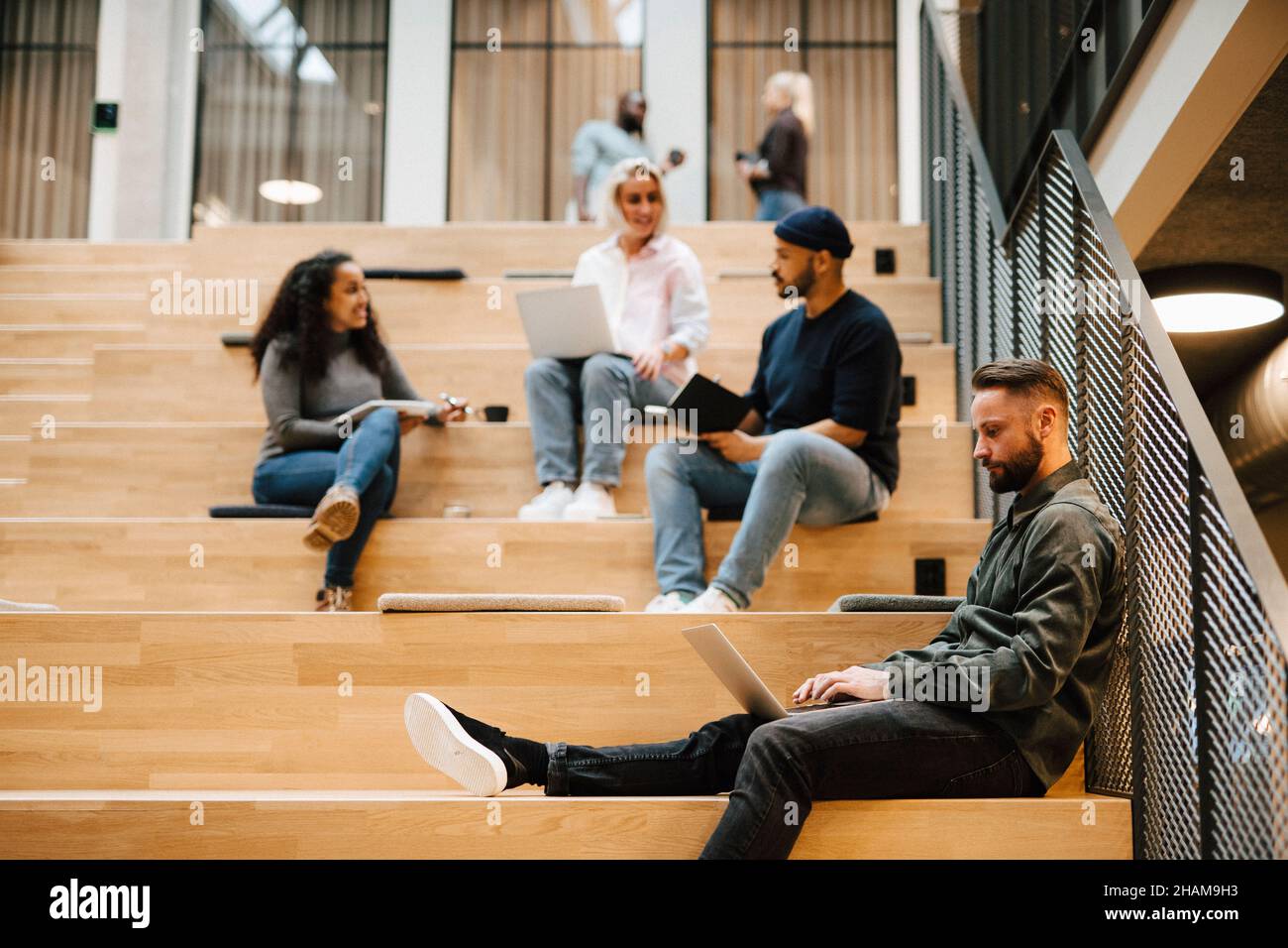 People relaxing on stairs in office building Stock Photo - Alamy