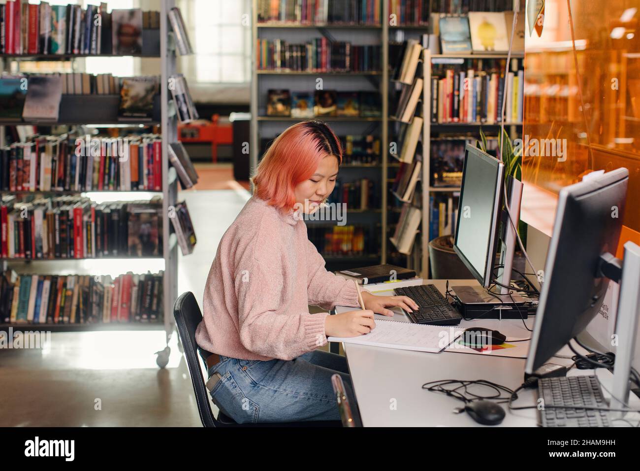 Woman studying in library Stock Photo - Alamy