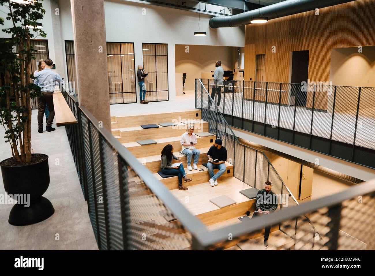 People relaxing on stairs in office building Stock Photo - Alamy