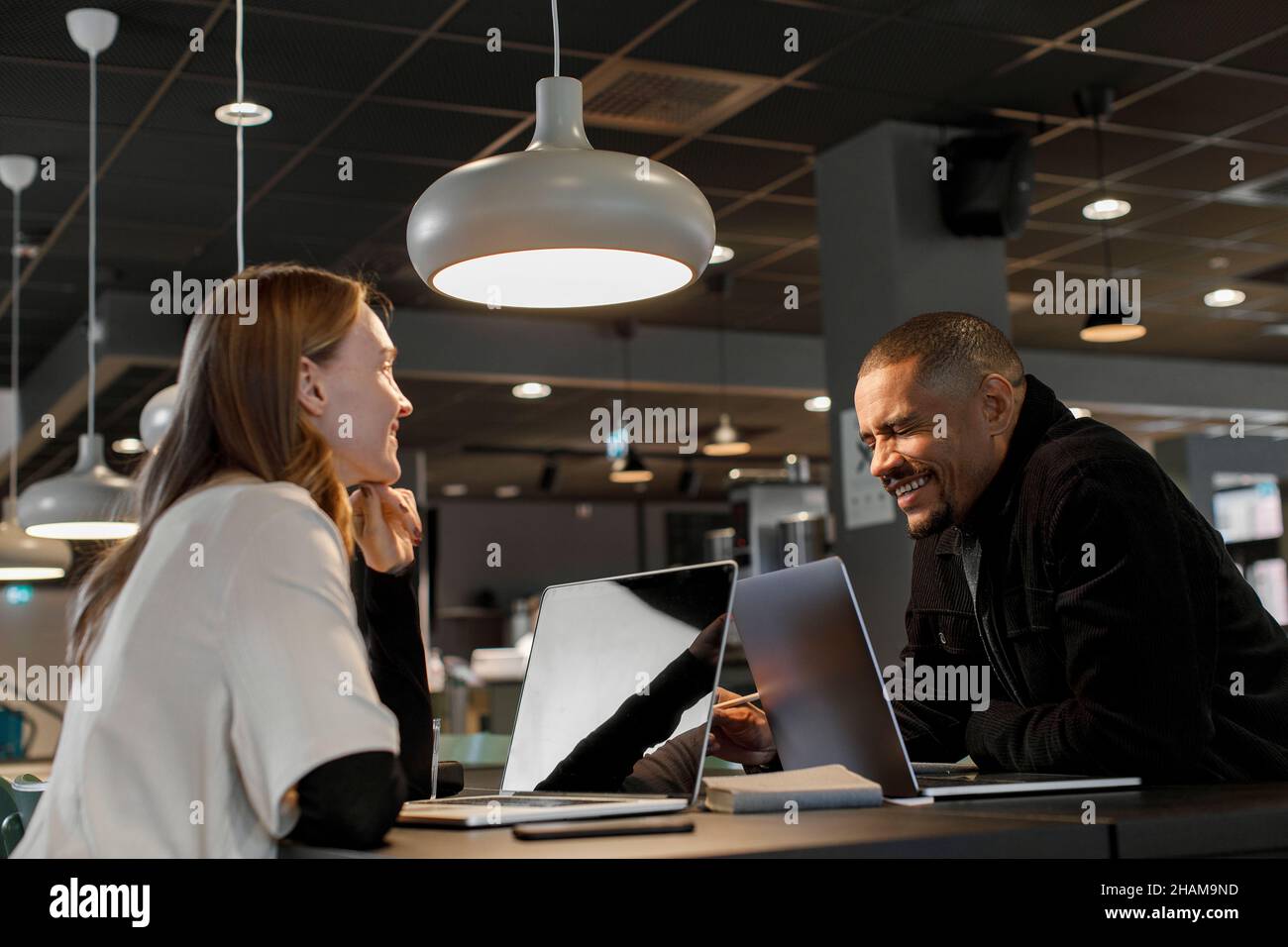 Coworkers talking in office Stock Photo - Alamy