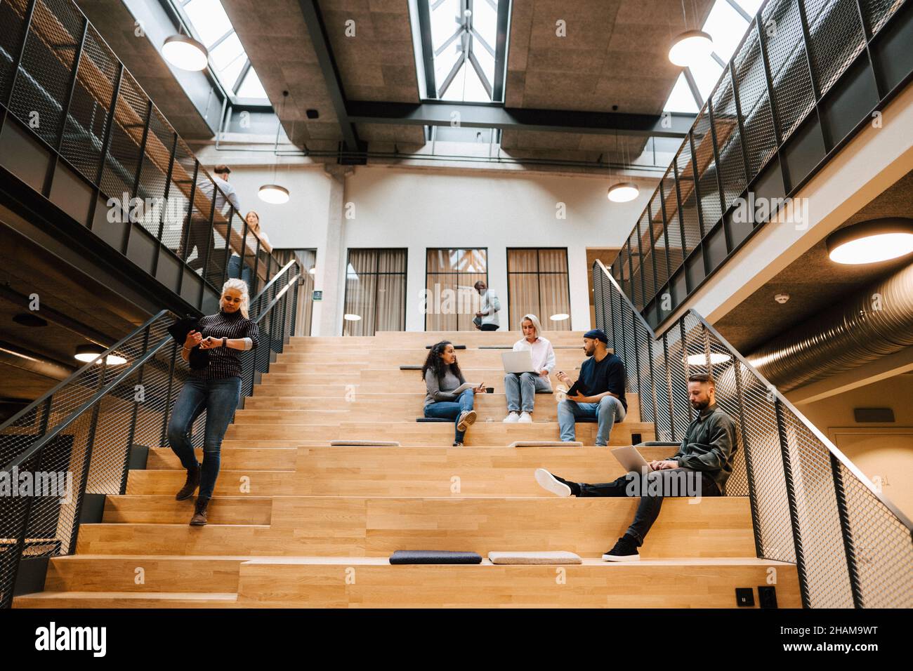 People relaxing on stairs in office building Stock Photo - Alamy