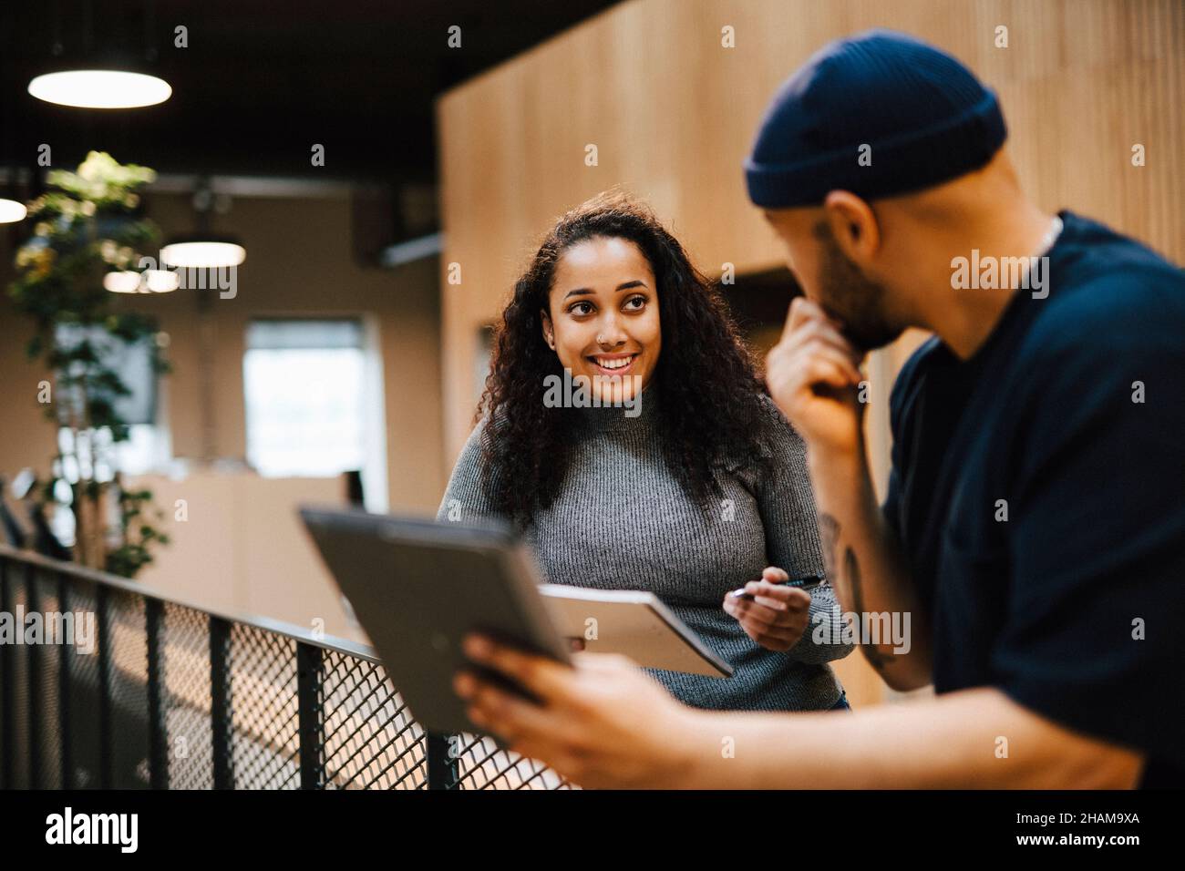Coworkers talking at corridor Stock Photo - Alamy