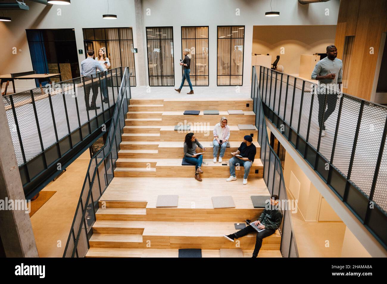 People relaxing on stairs in office building Stock Photo - Alamy