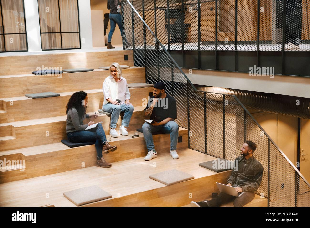 People relaxing on stairs in office building Stock Photo - Alamy