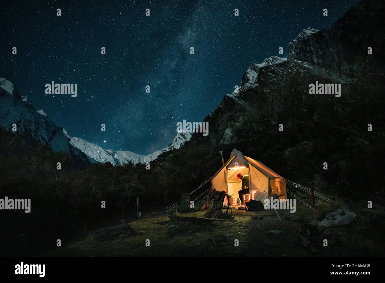 Hunter sitting in tent at night Stock Photo - Alamy