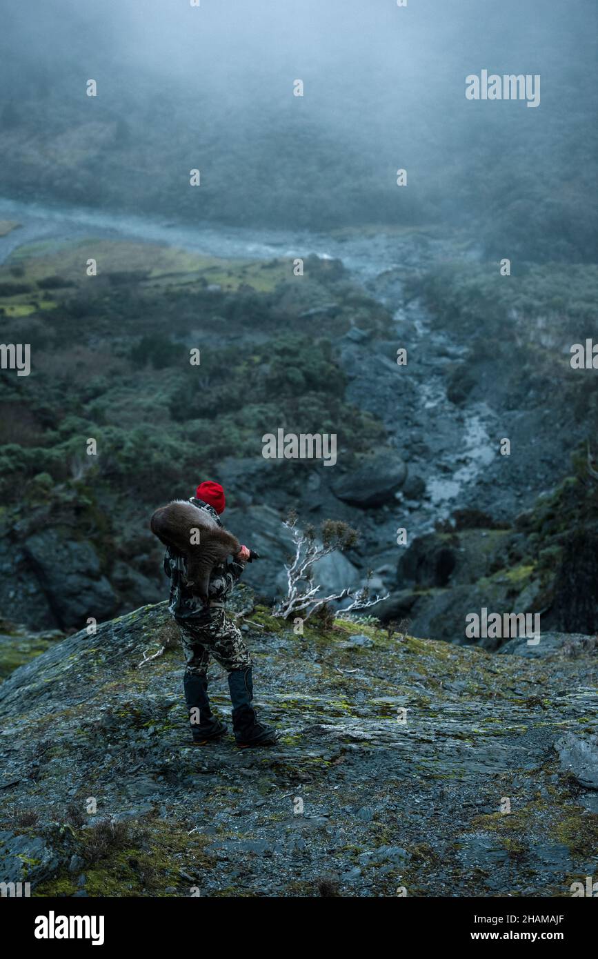Hunter carrying dead mountain goat Stock Photo - Alamy