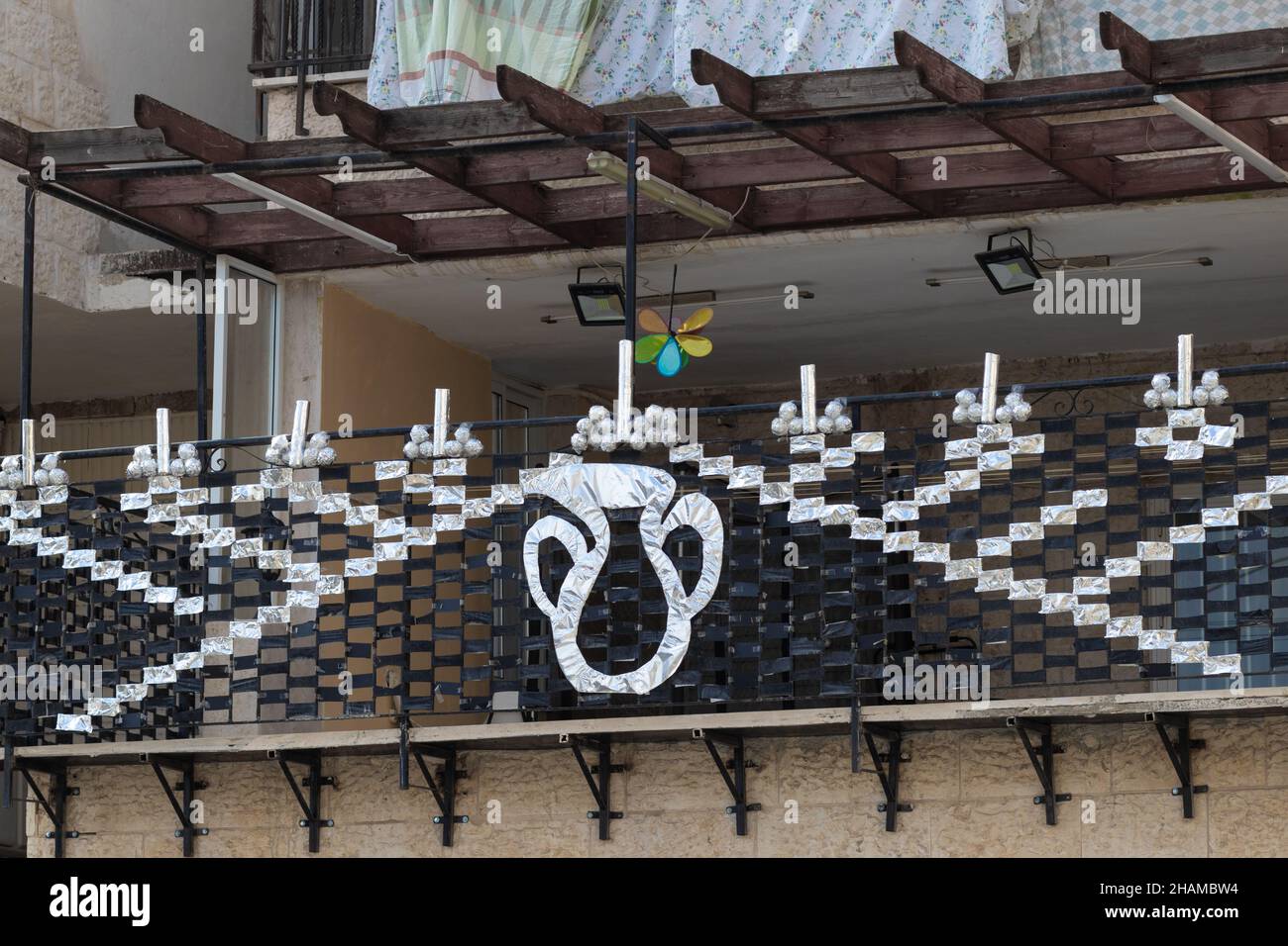 Large and decorated menorah in silver color, on the balcony of a house ...