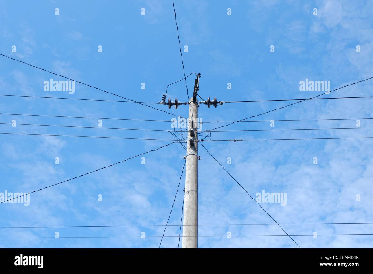 Electrical power pole with many cables connecting to it with blue sky ...
