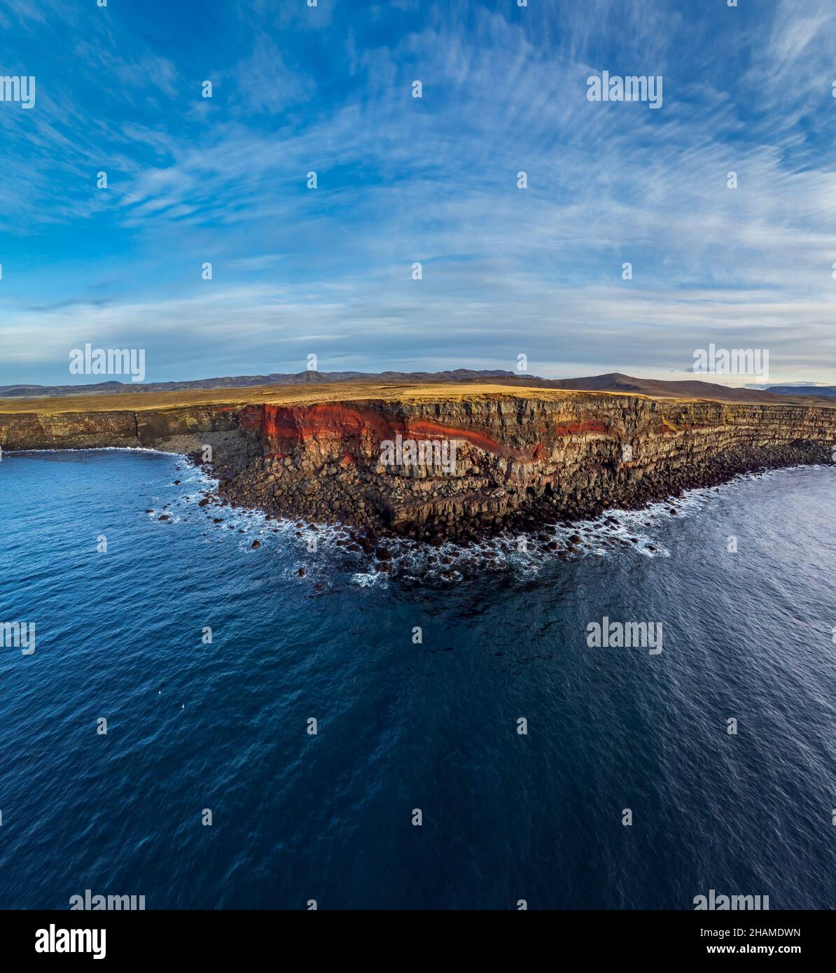 Spectacular volcano cliffs with red layers over volcanic coastline ...