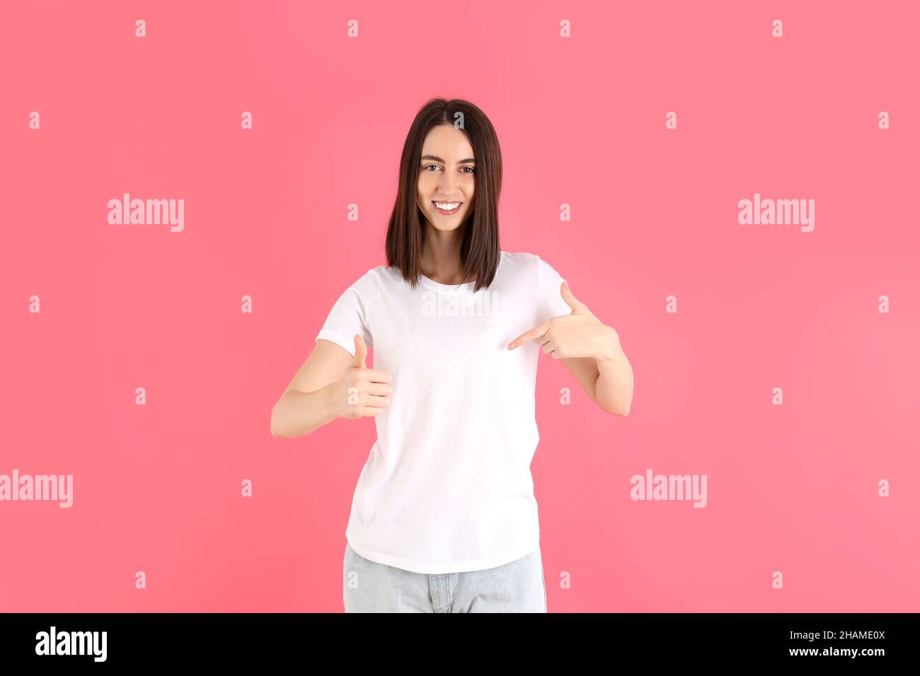 Attractive girl in white t-shirt on pink background Stock Photo - Alamy