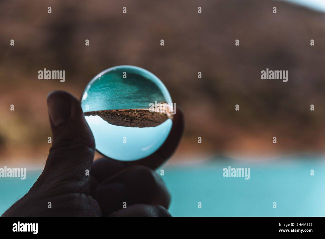 A crystal ball reflecting the seascape upside down in the blurred ...