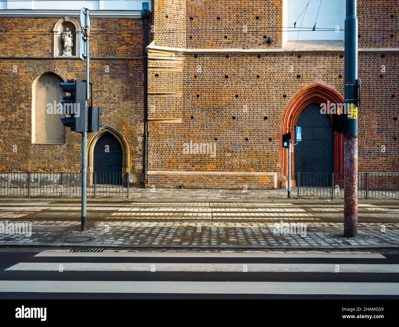 Old brick wall, a worn urban street with crosswalk, a concrete sidewalk ...