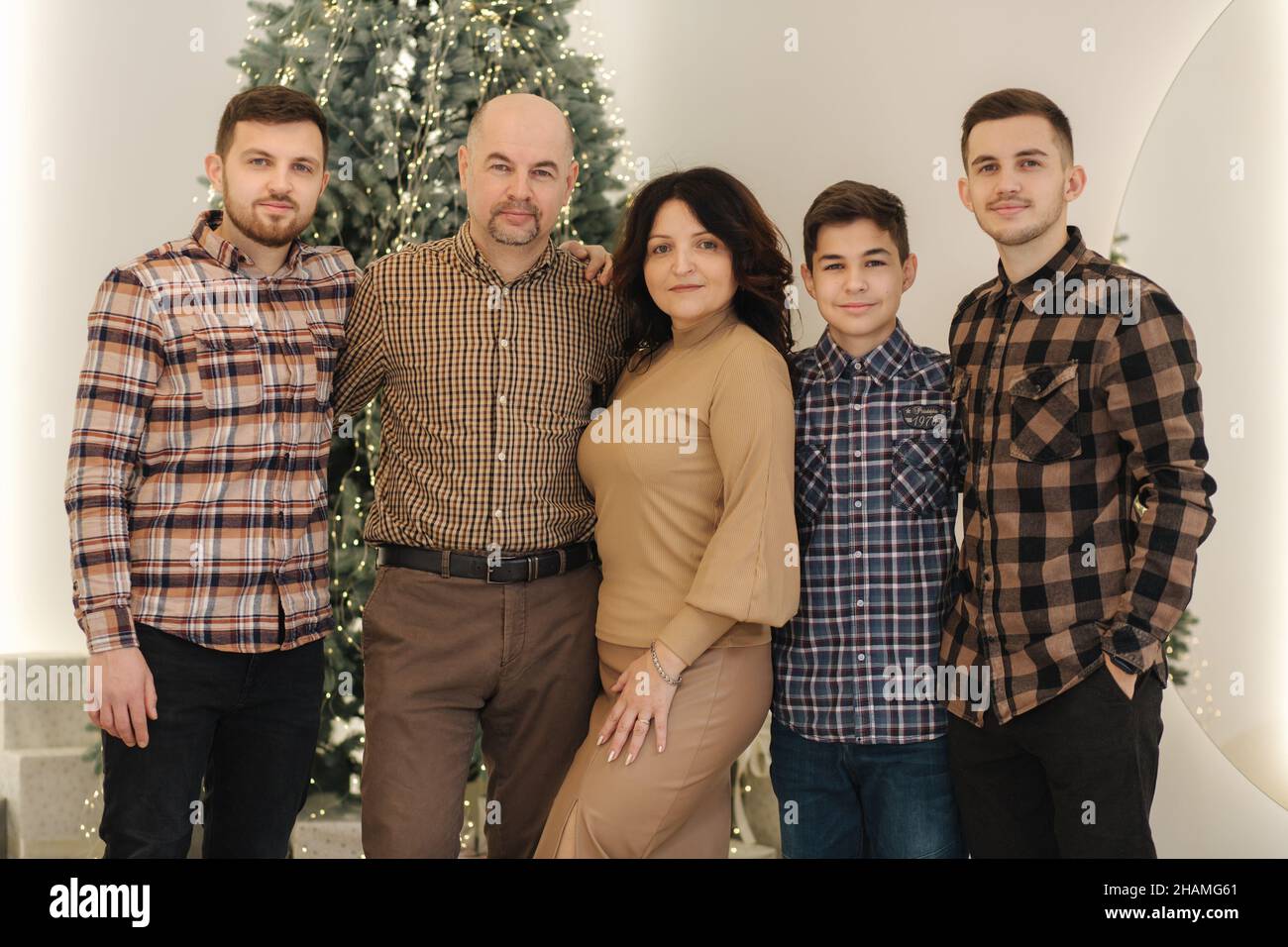Mother and father with their three sons smile. Big family of four man ...