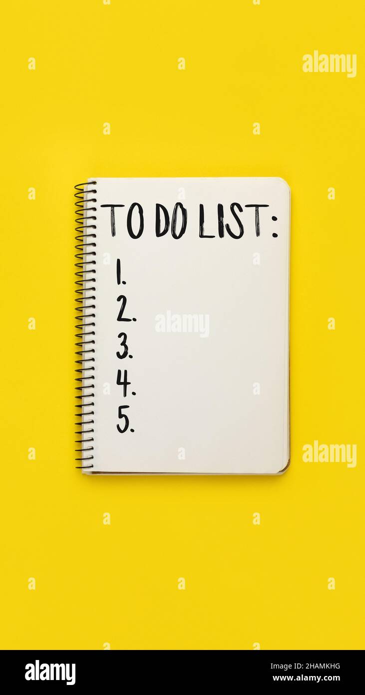 Open spiral notebook with to do list on bright yellow background, top ...