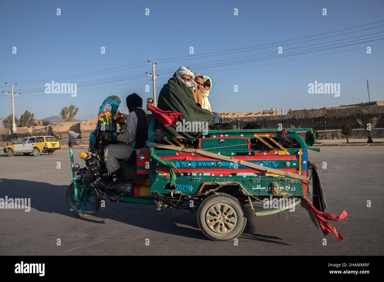 EDITORIAL USE ONLY - Men going to work in a rickshaw in Kandahar city ...