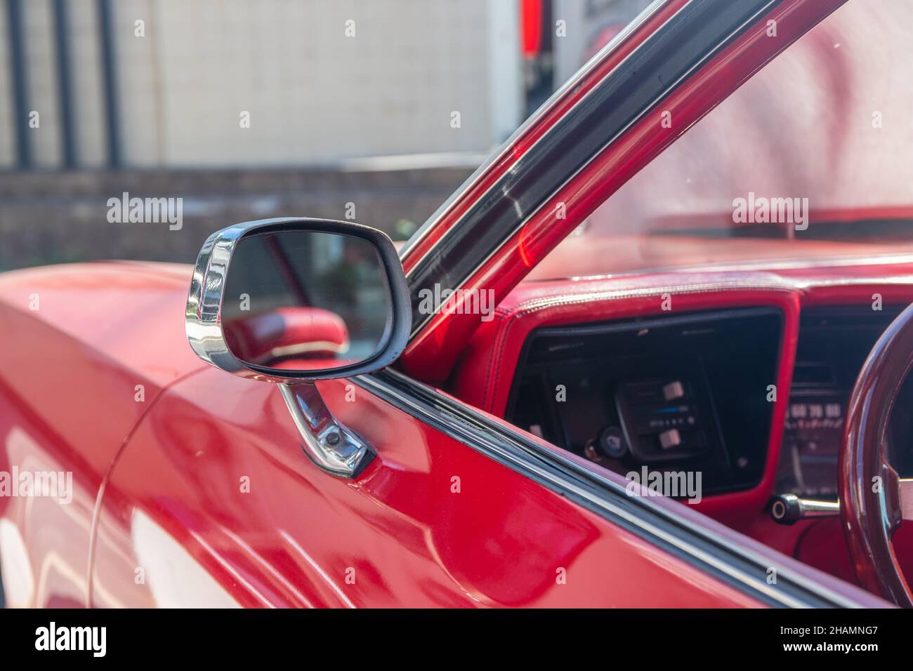 The vehicle's wing mirror of a red classic car or Muscle car at a ...