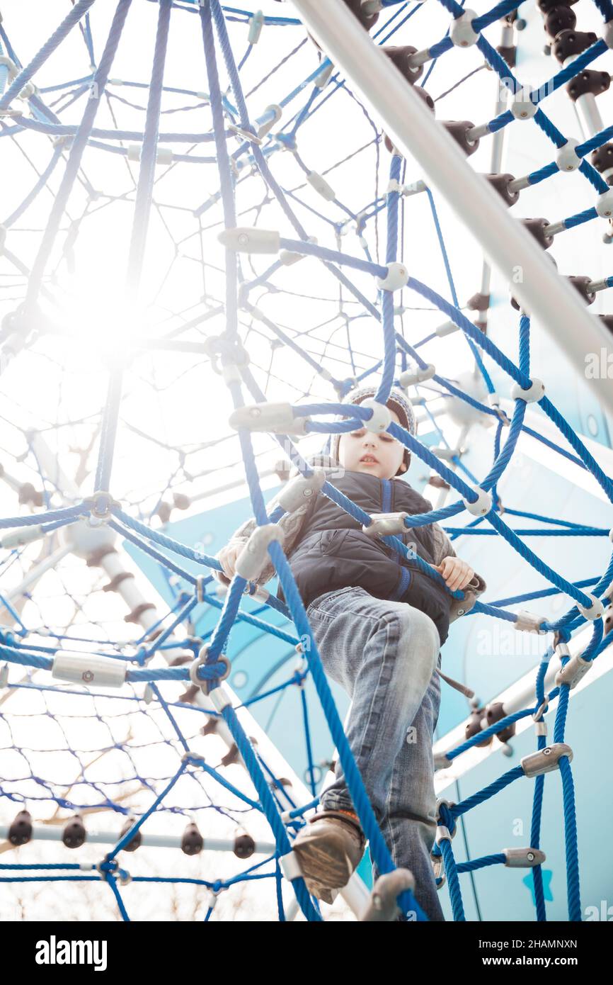 beautiful little boy playing in a rope maze Stock Photo - Alamy