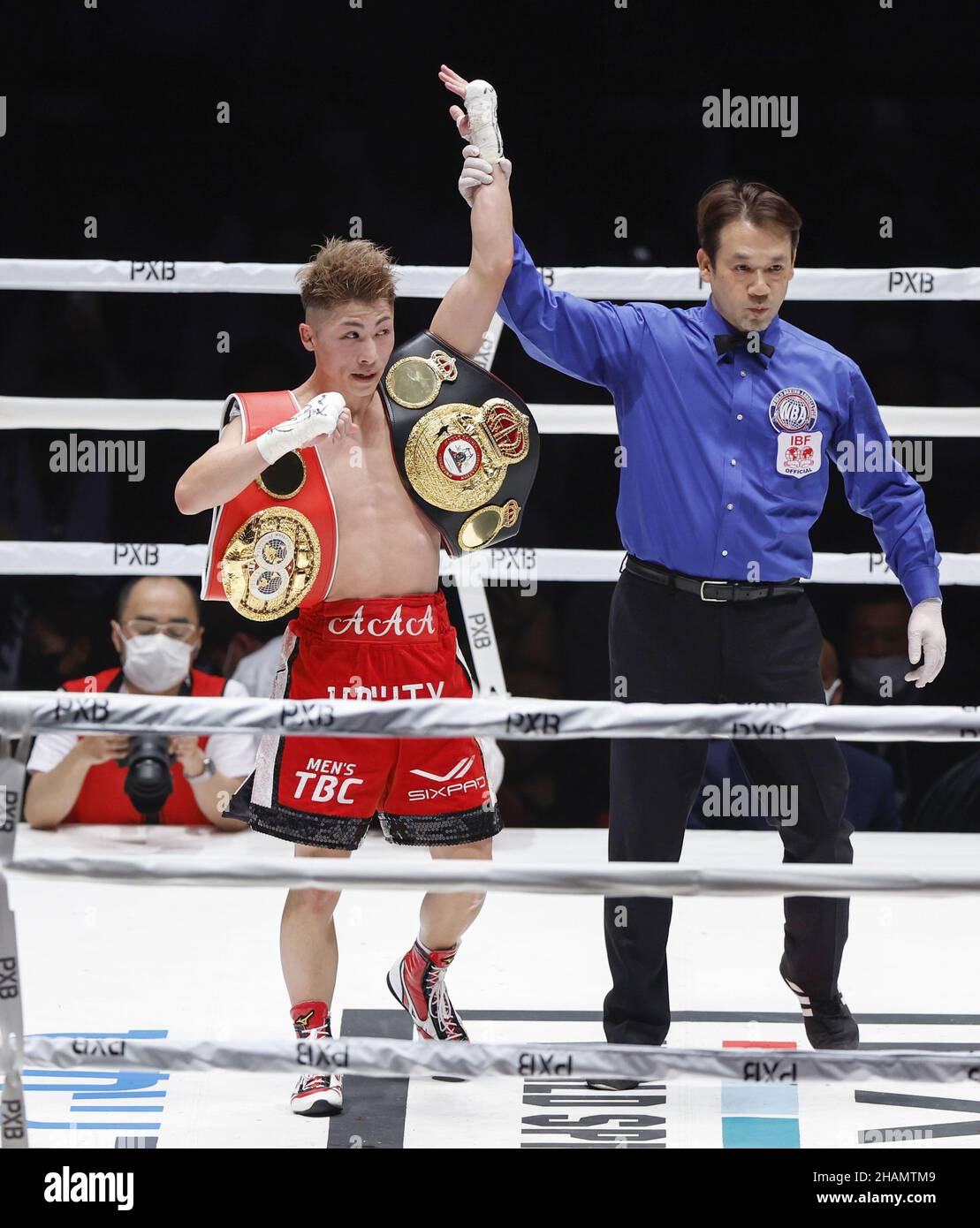 WBA and IBF bantamweight champion Naoya Inoue of Japan (L) raises a glove after his eighth-round ...