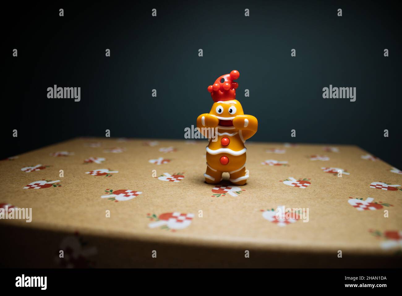 Gingerbread man smiling on a Christmas present with a blue background ...