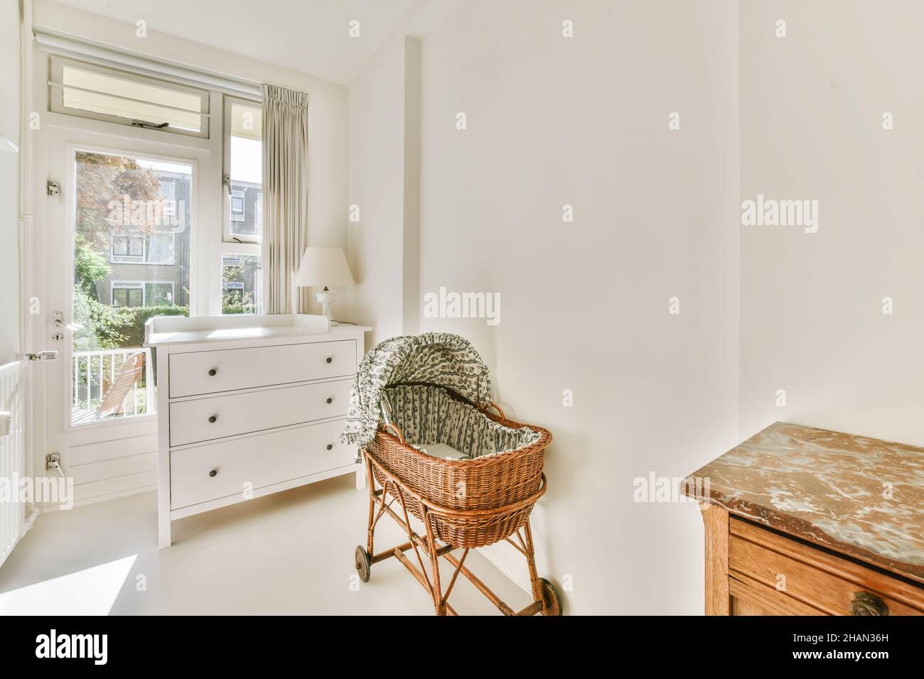 Bright little room with a small knitted baby stroller Stock Photo - Alamy