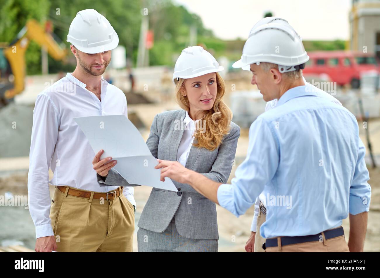 Woman with document looking questioningly at man Stock Photo - Alamy