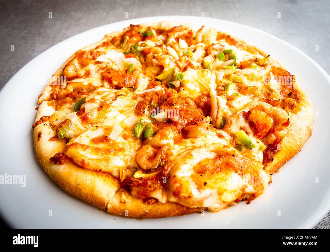 Seafood pizza on a round white plate Stock Photo - Alamy