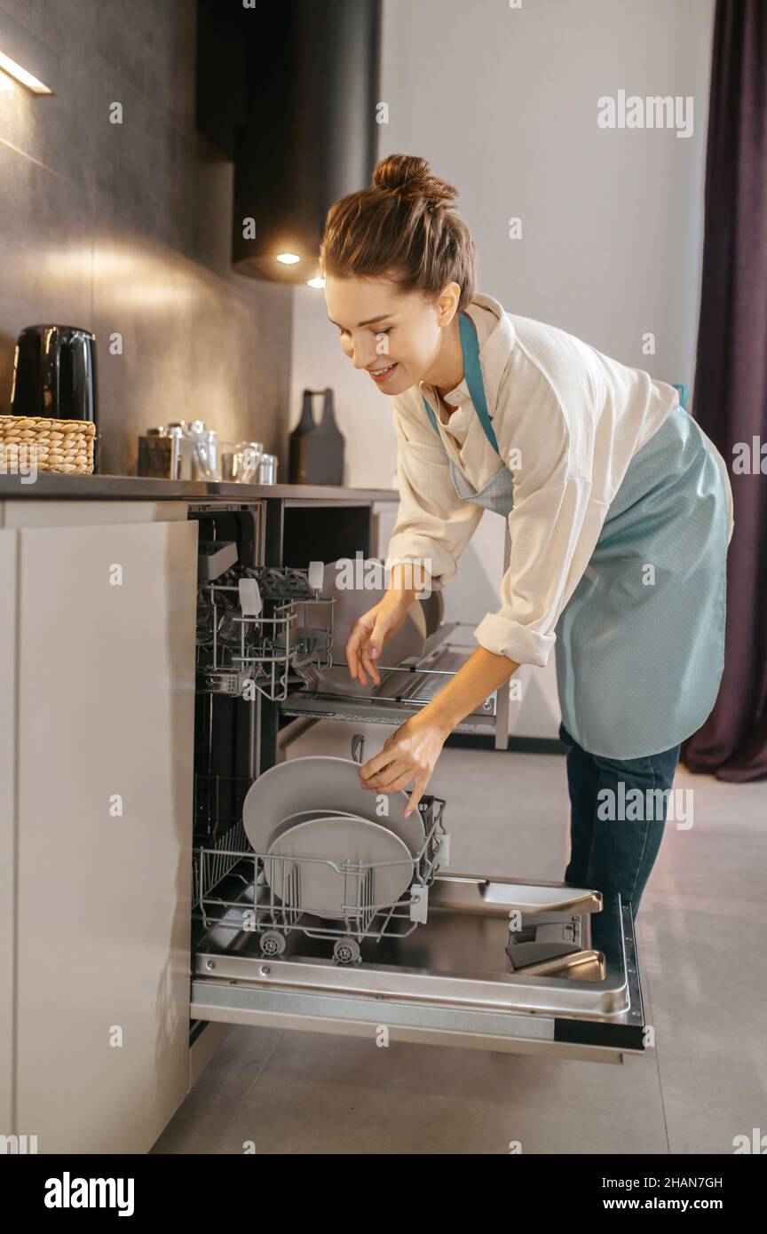 Housewife taking out clean plates hi-res stock photography and images ...