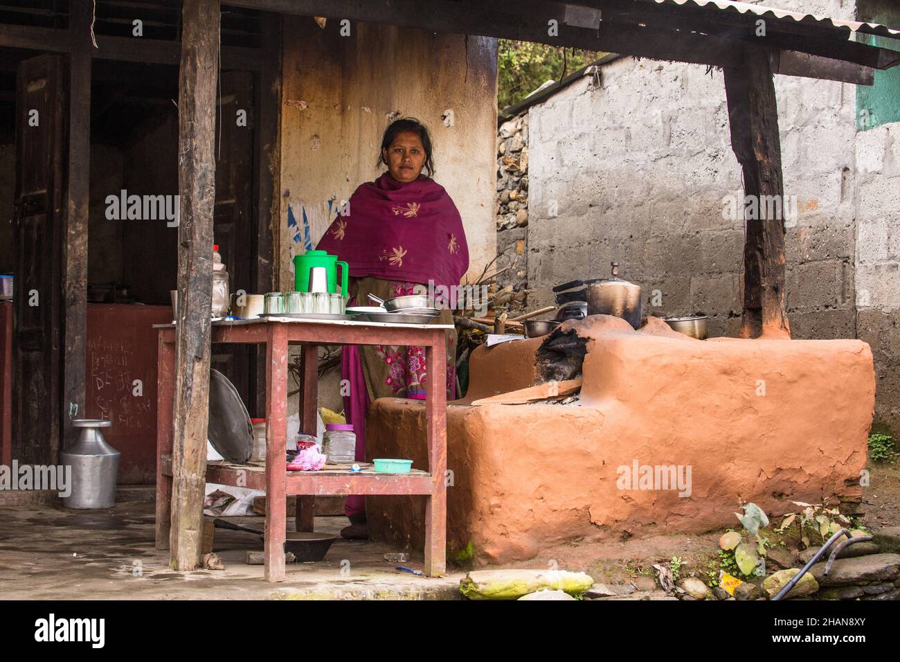 A Nepali woman in her outdoor kitchen with a chulo or traditional wood ...