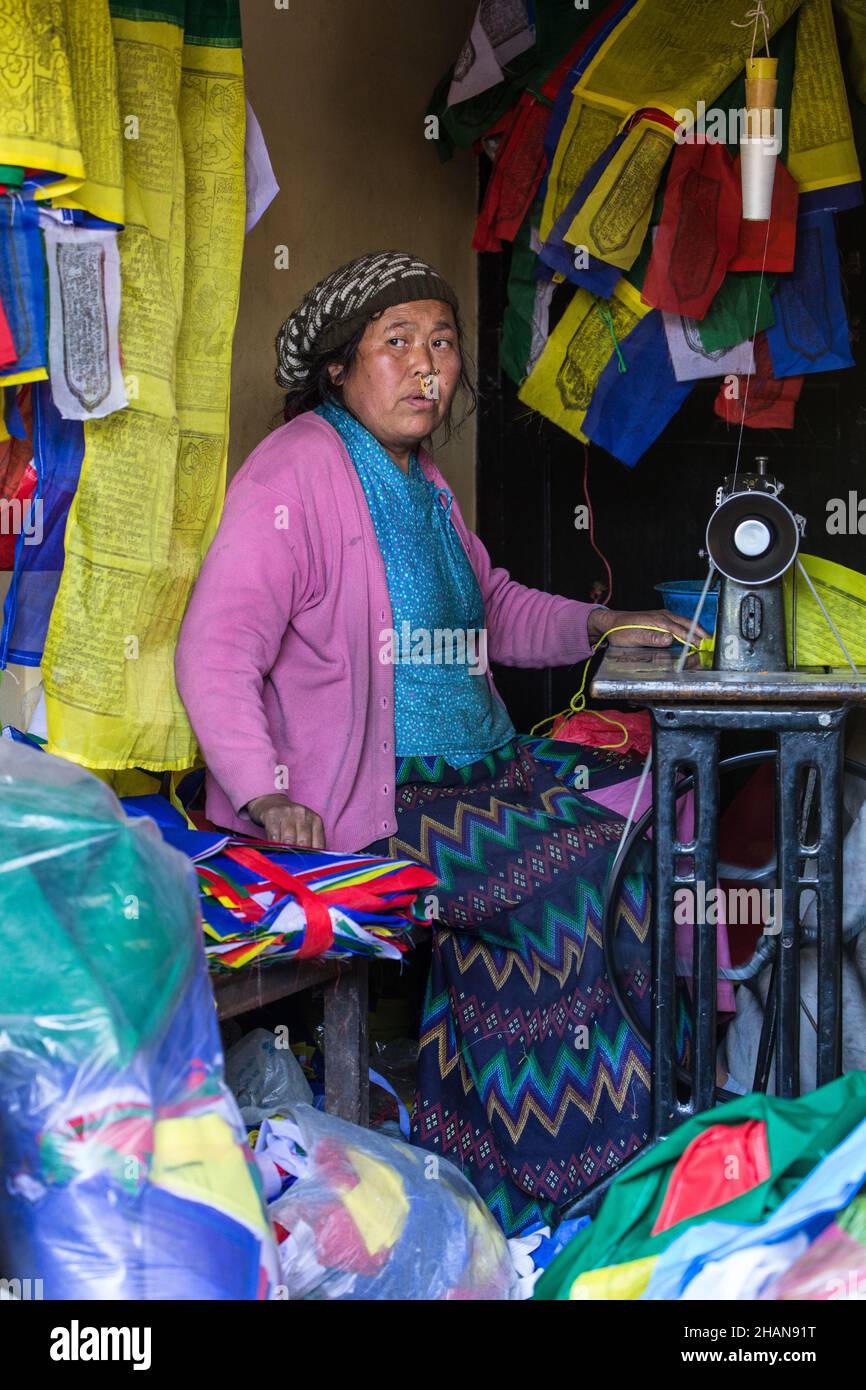 A Newari woman sews Buddhist prayer flags on a foot-treadle sewing ...