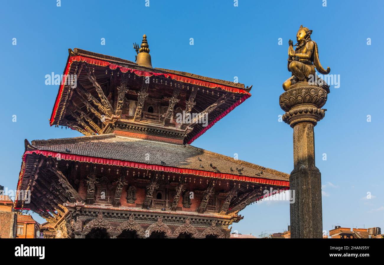 The brass statue of Garuda on a stone column in front of the Vishwanath ...