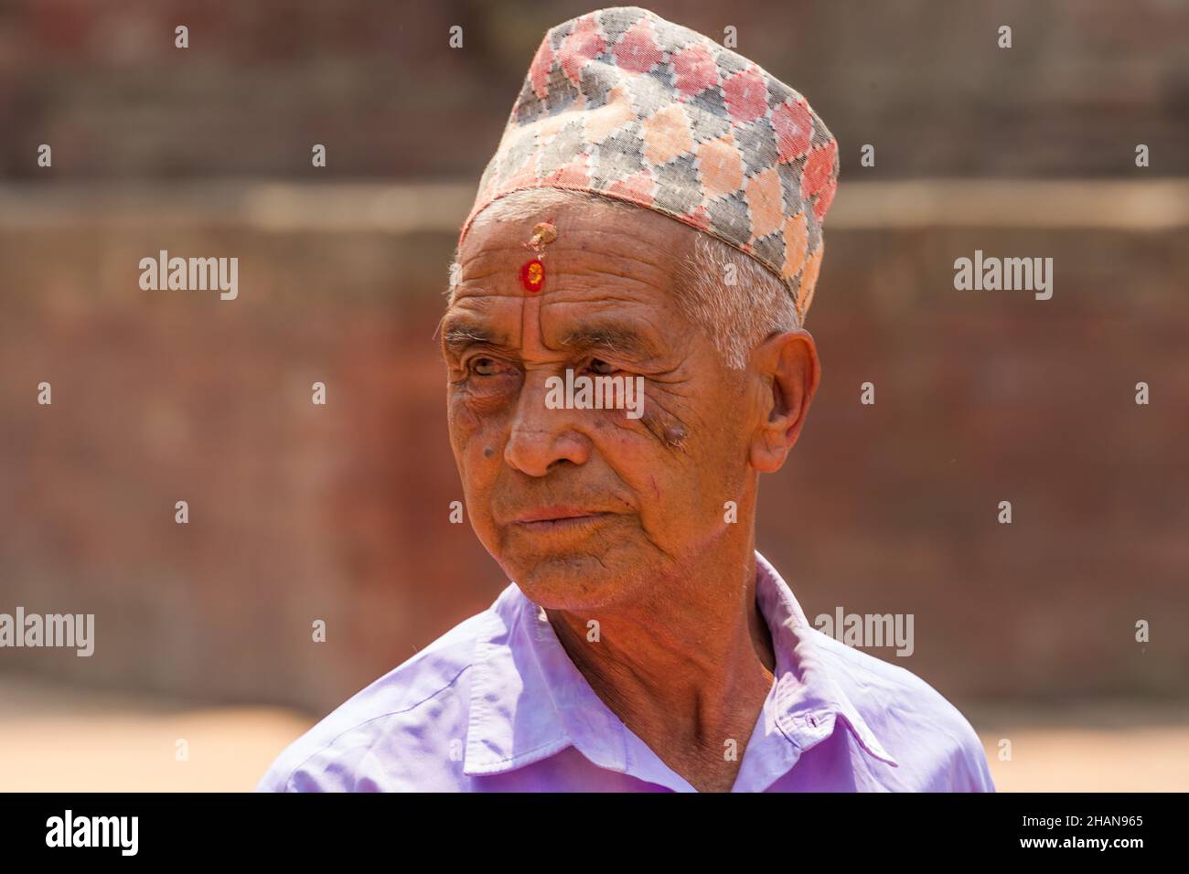 An older Nepali Hindu man wearing the traditional dhaka topi cap and ...