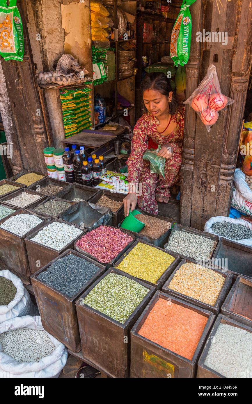 An attractive Nepali woman in traditional attire selling beans and ...