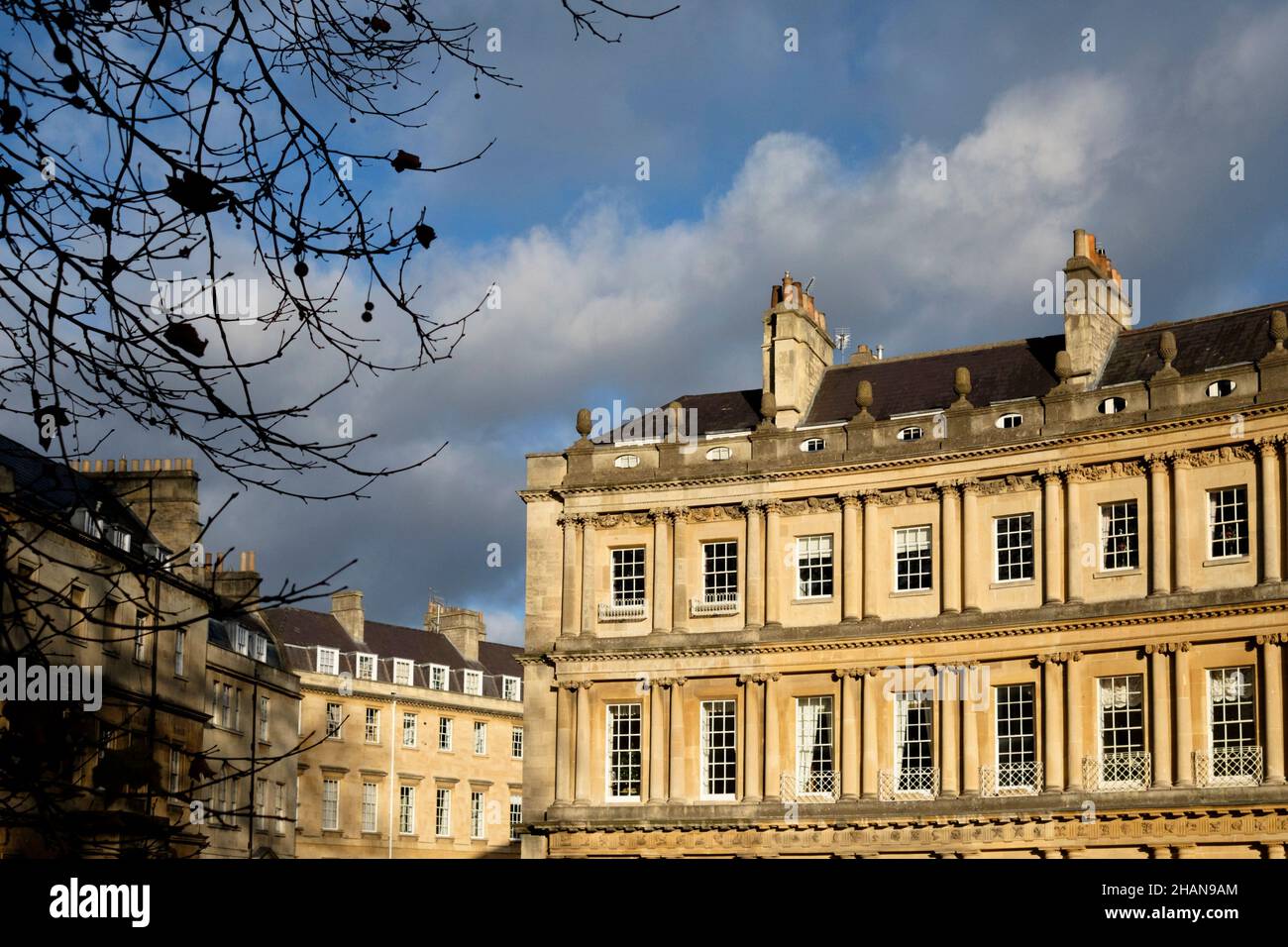 Honey coloured sandstone buildings of the Circus in Bath against a dark ...