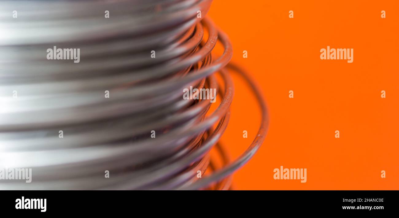 Coil with steel wires isolated on an orange background Stock Photo - Alamy
