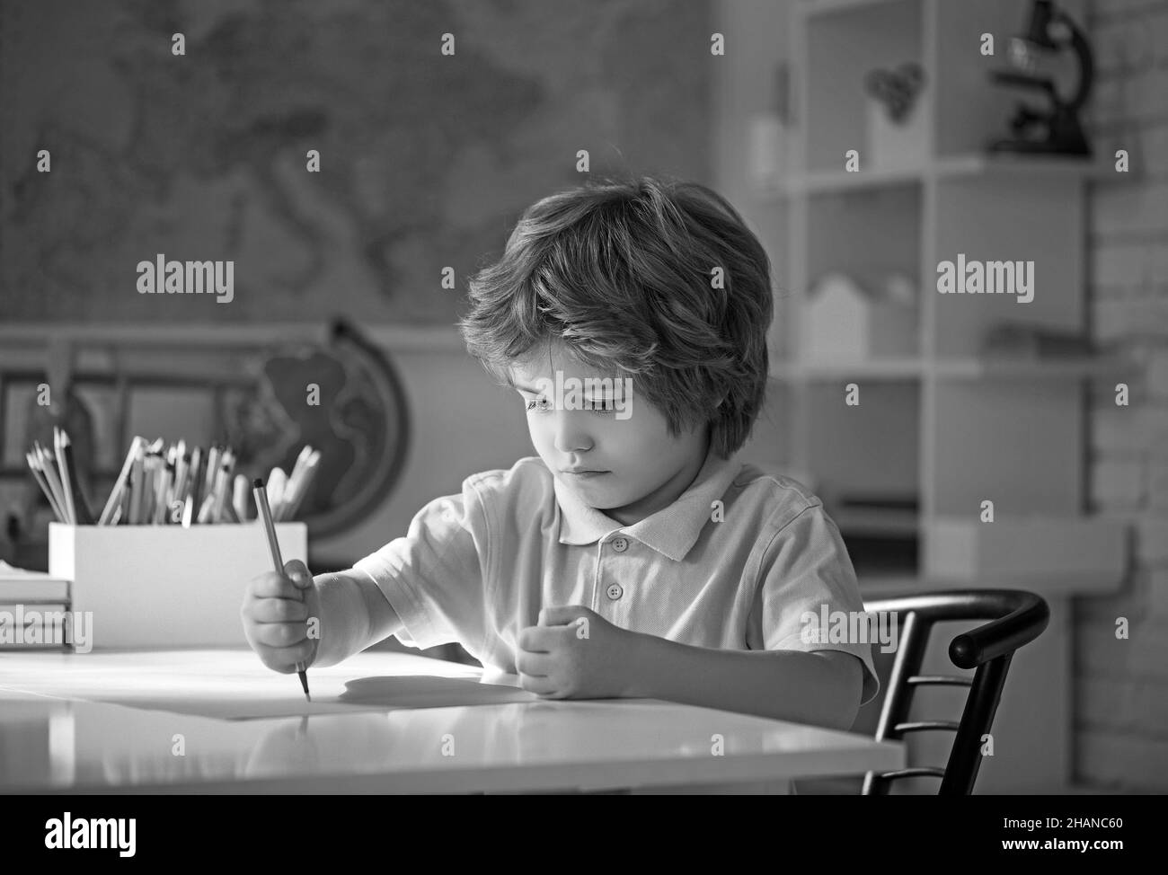 Smiling little boy drawing in the room Stock Photo - Alamy