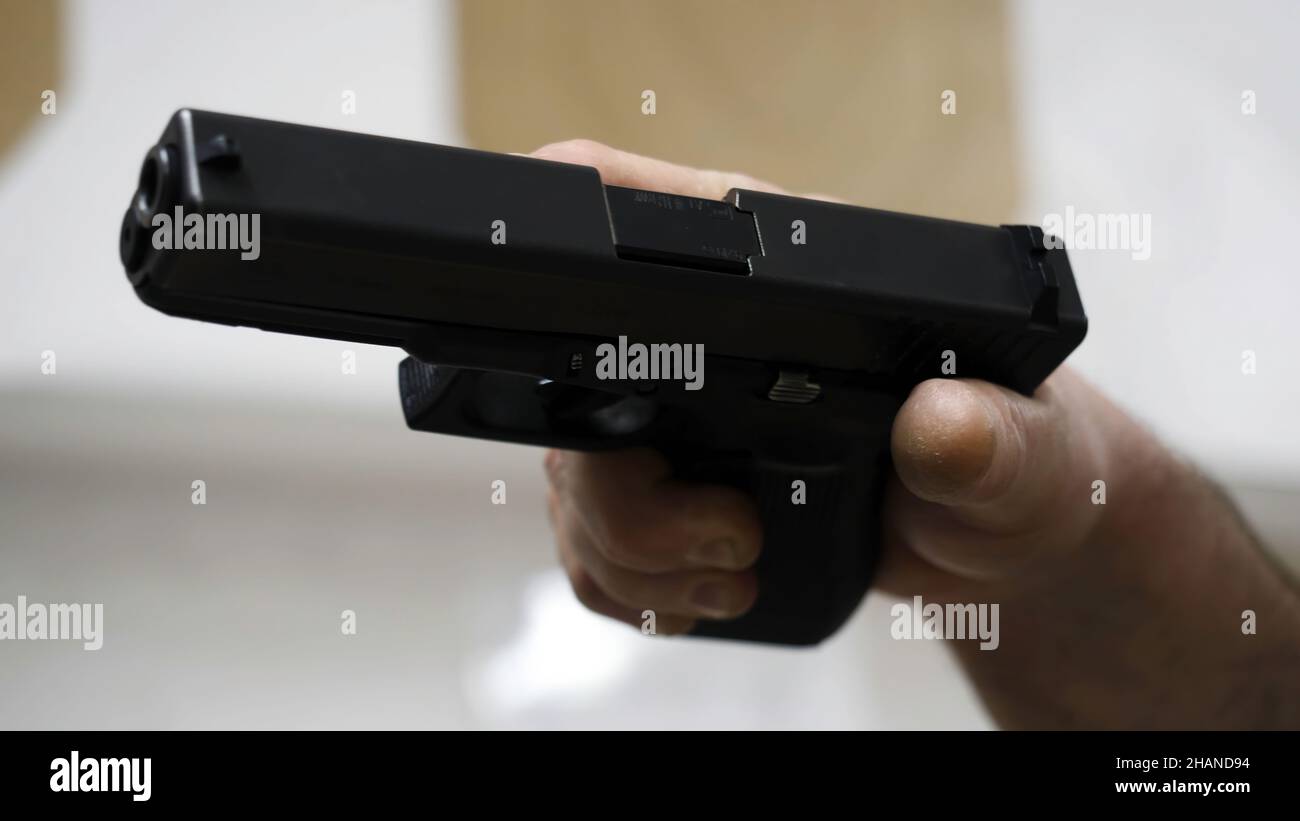 Gun in the man's hand. Man holding a gun close-up. Black handgun in ...