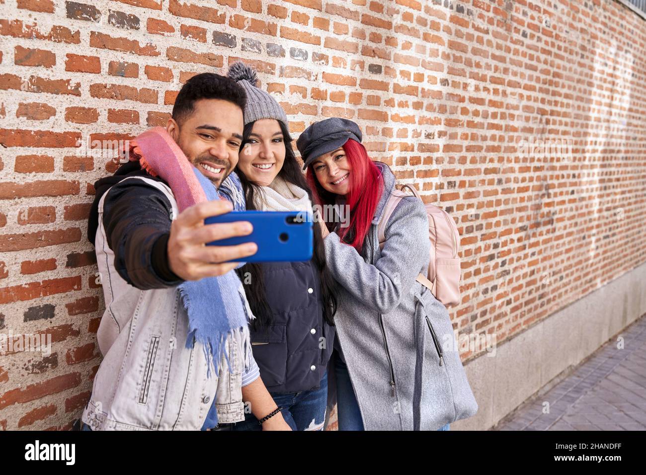 Positive multiracial male and female friends in stylish outfits smiling ...
