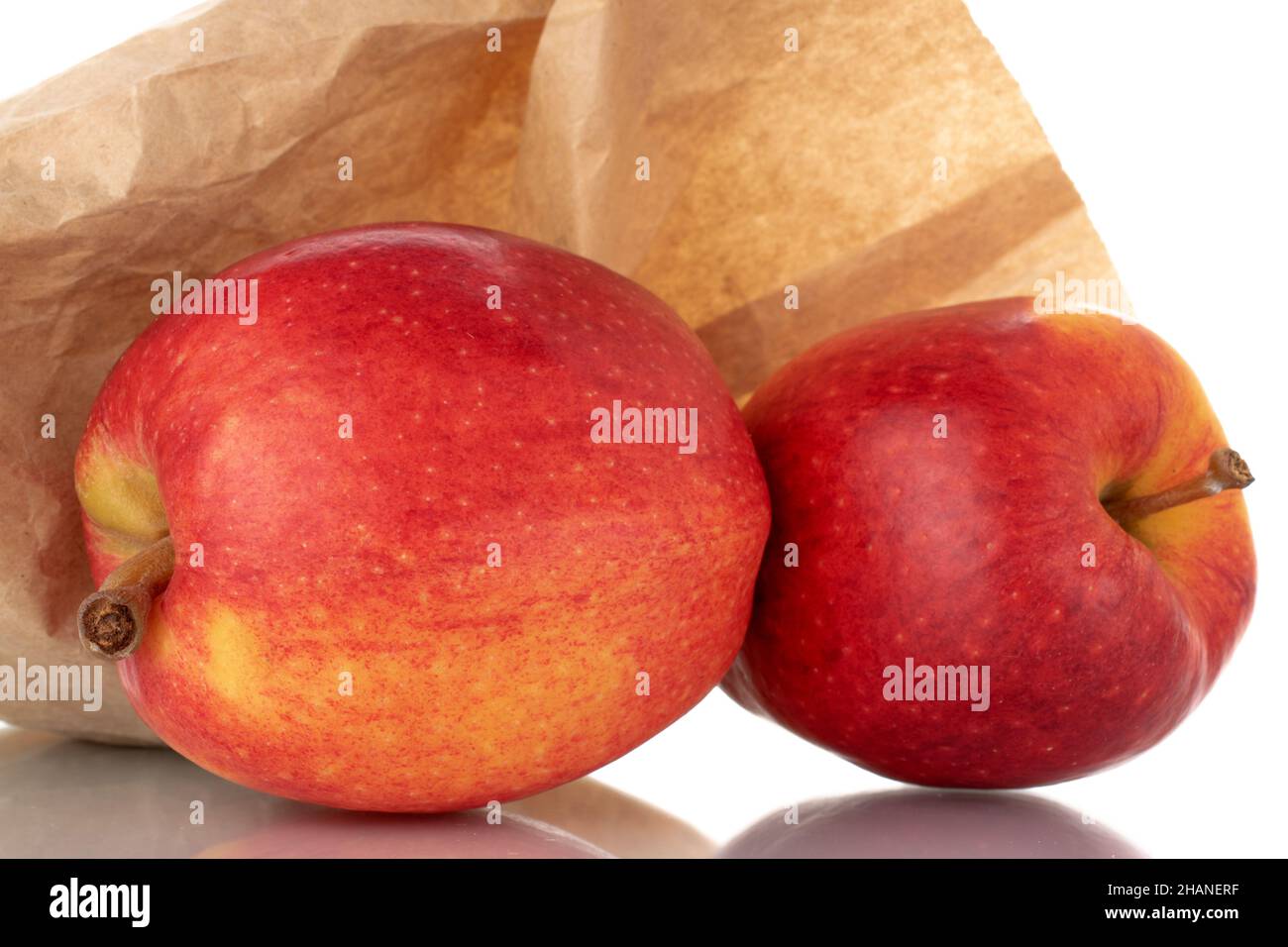 Two organic red apples with a paper bag, close-up, isolated on white ...