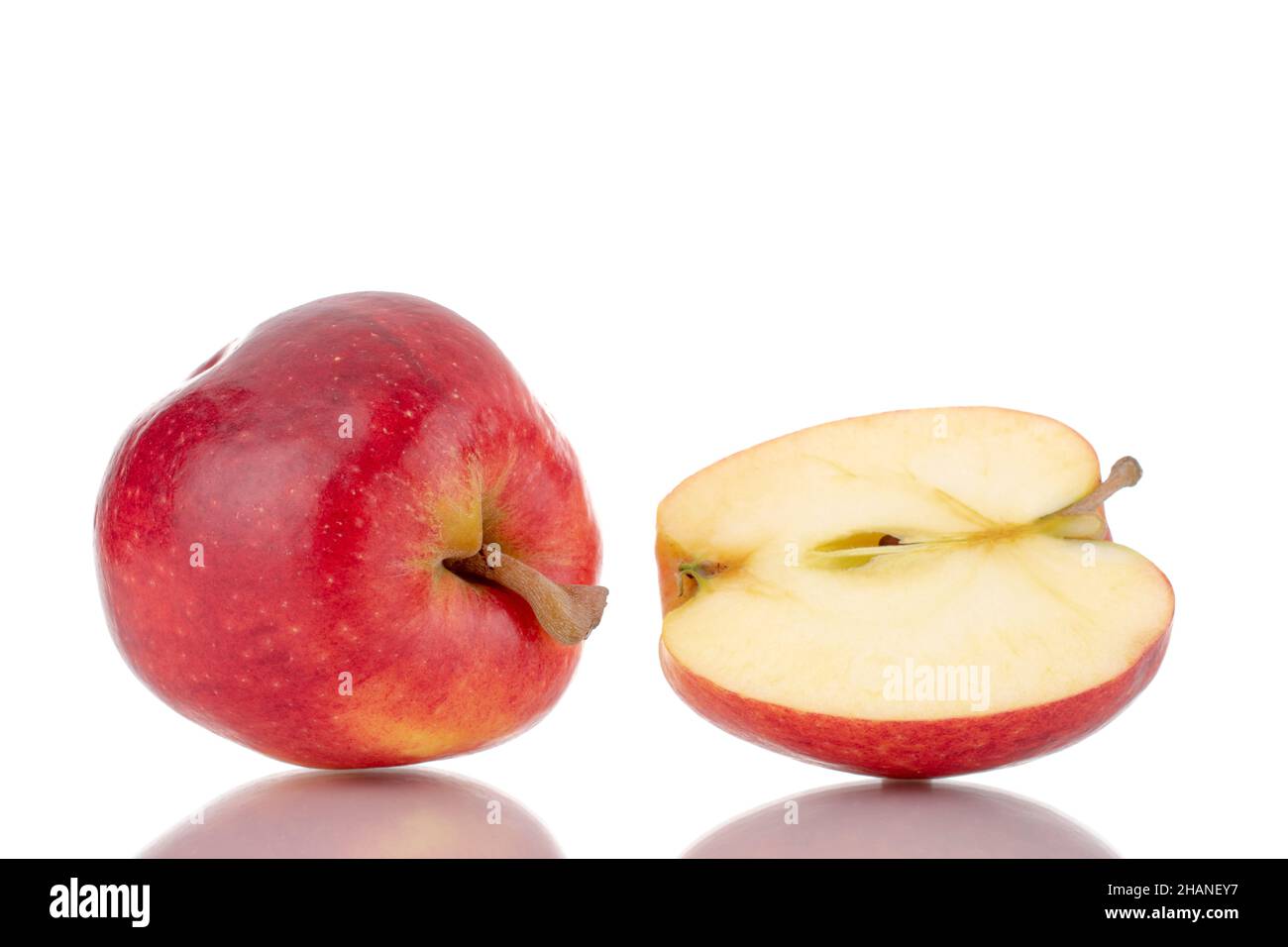 One half and one whole organic red apples, close-up, isolated on white ...