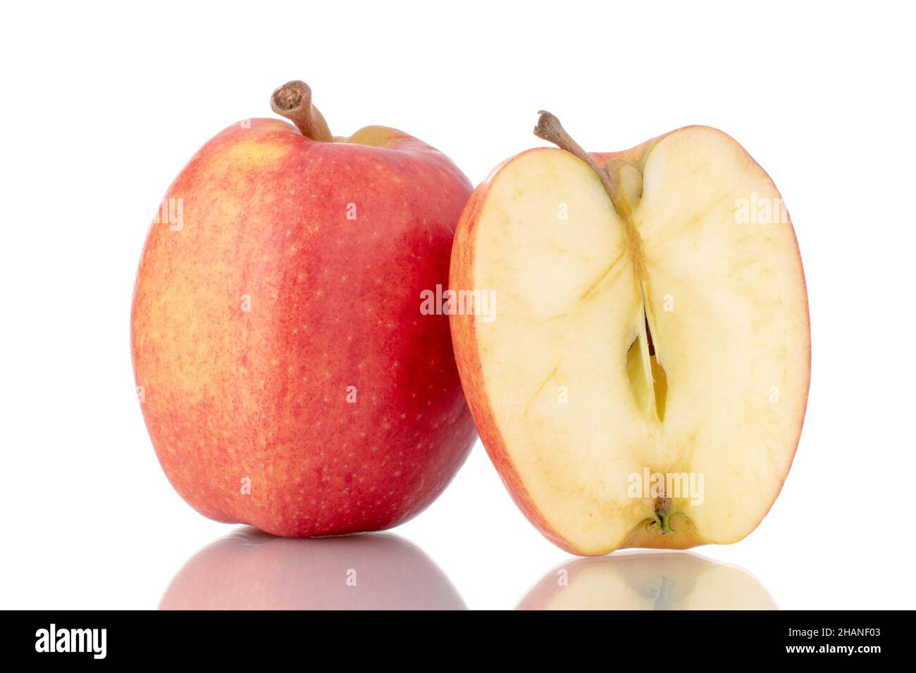 One half and one whole organic red apples, close-up, isolated on white ...