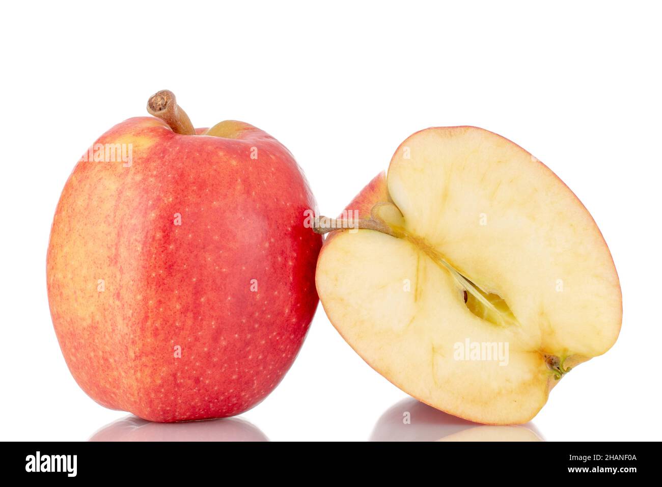 One half and one whole organic red apples, close-up, isolated on white ...