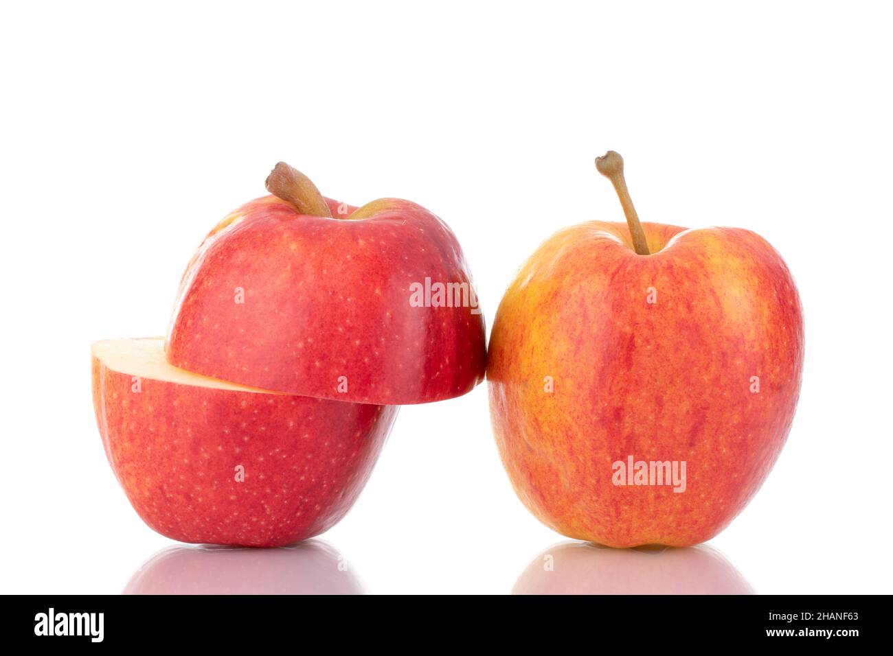 Two halves and one whole organic red apples, close-up, isolated on ...