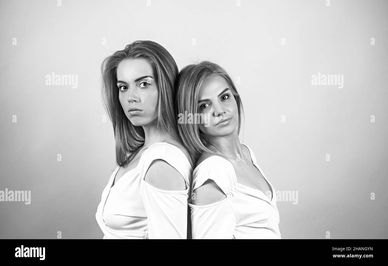 Gorgeous two caucasian sisters models posing together on beige ...