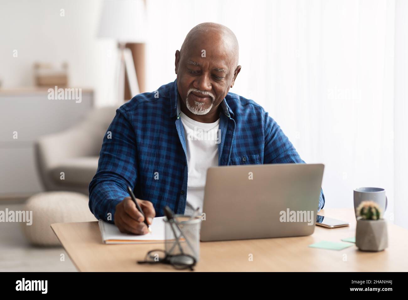 Senior Black Man At Laptop Taking Notes Indoors Stock Photo - Alamy