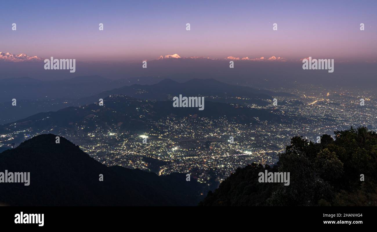 A view of the Himalaya Mountains glowing pink in the sunset and the ...