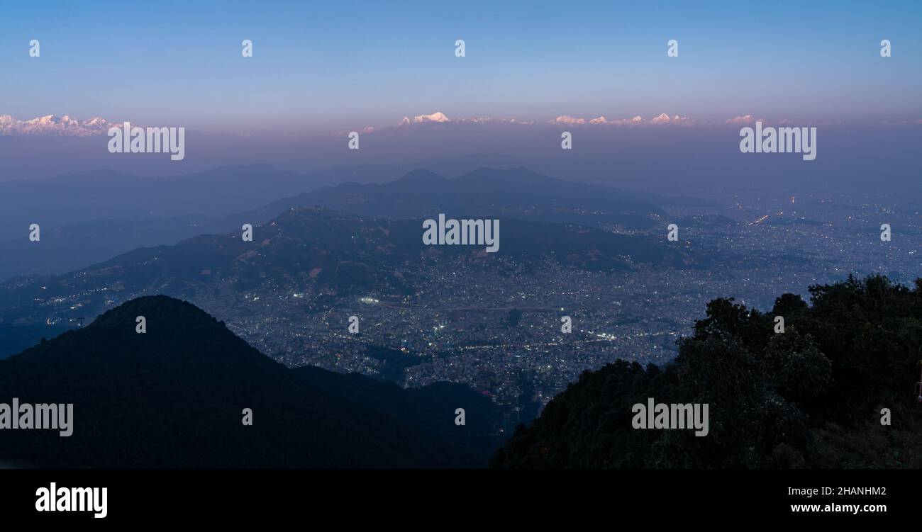 A view of the Himalaya Mountains glowing pink in the sunset and the ...