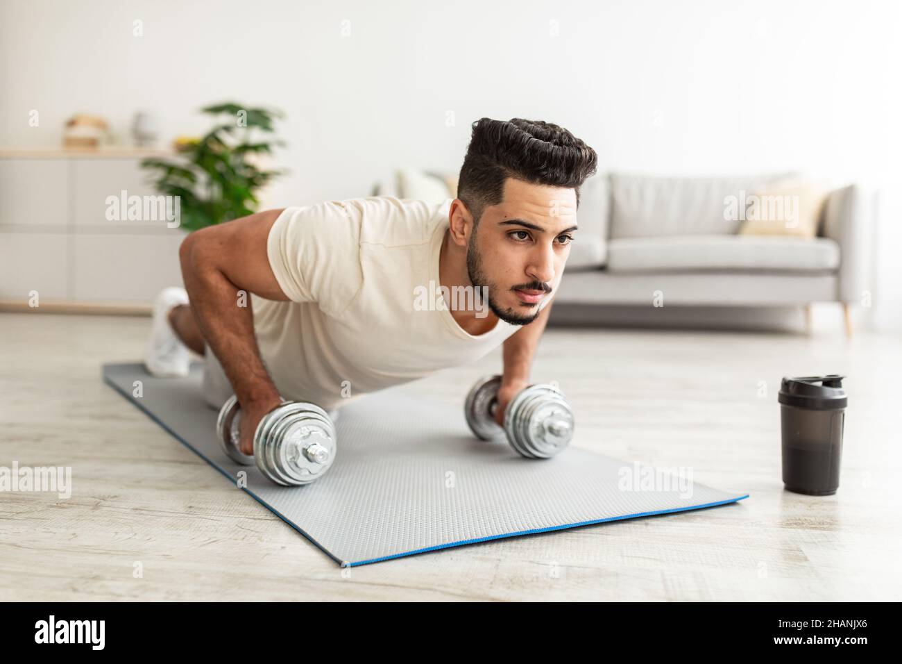 Stay home sports. Handsome young Arab man standing in plank pose with ...